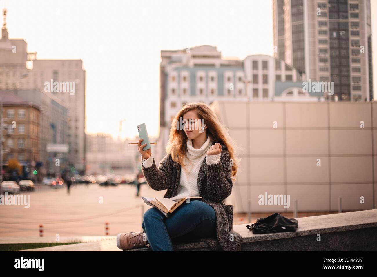 Happy teenage student girl doing video call using smart phone at campus ...