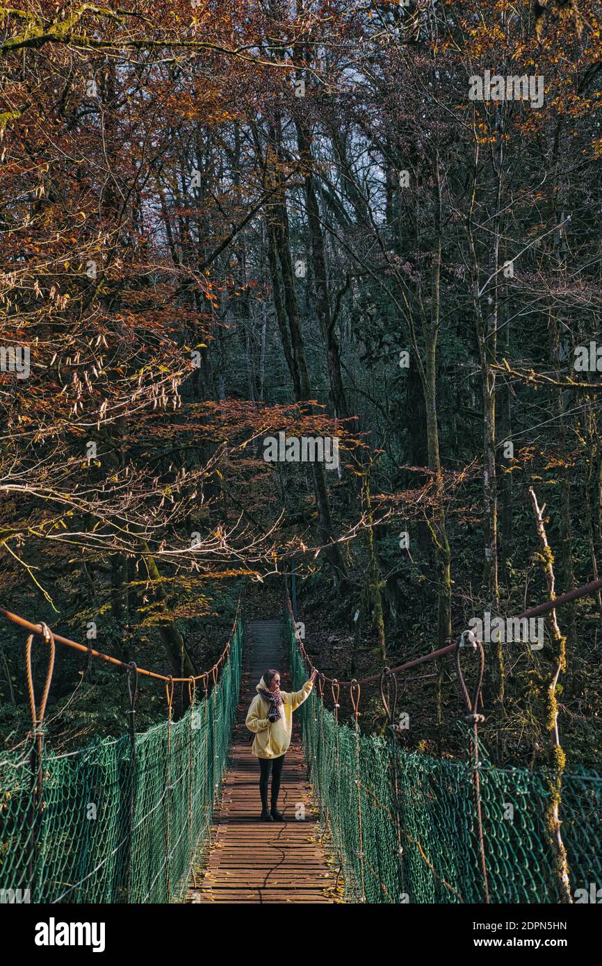 Young woman crossing suspension bridge Stock Photo - Alamy