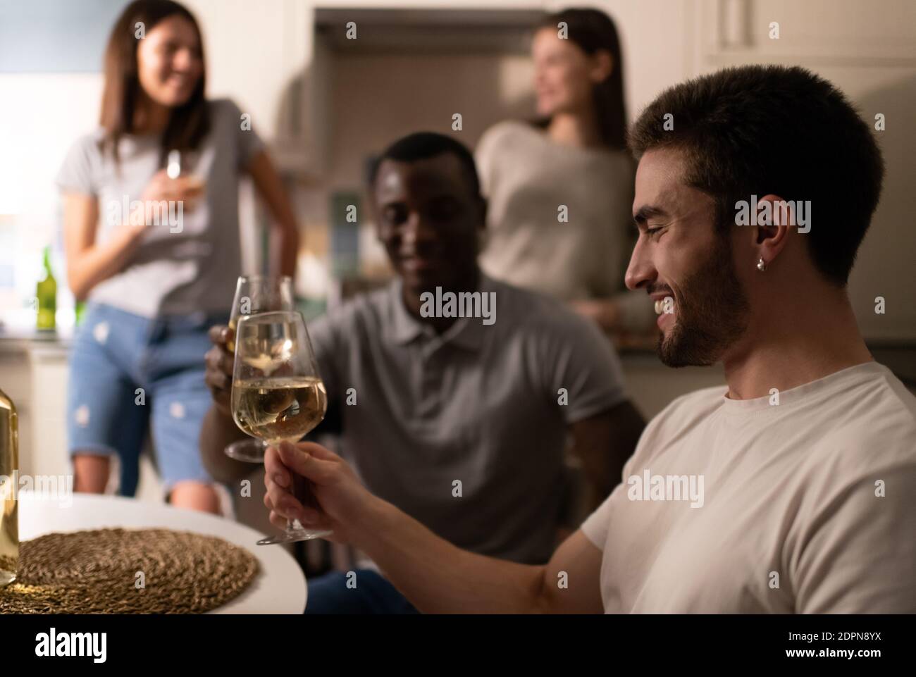 Side view of cheerful young man proposing toast while resting during ...
