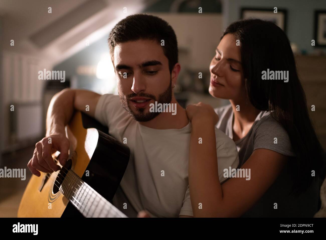 Bearded Young Guy Playing Acoustic Guitar For Woman While Resting