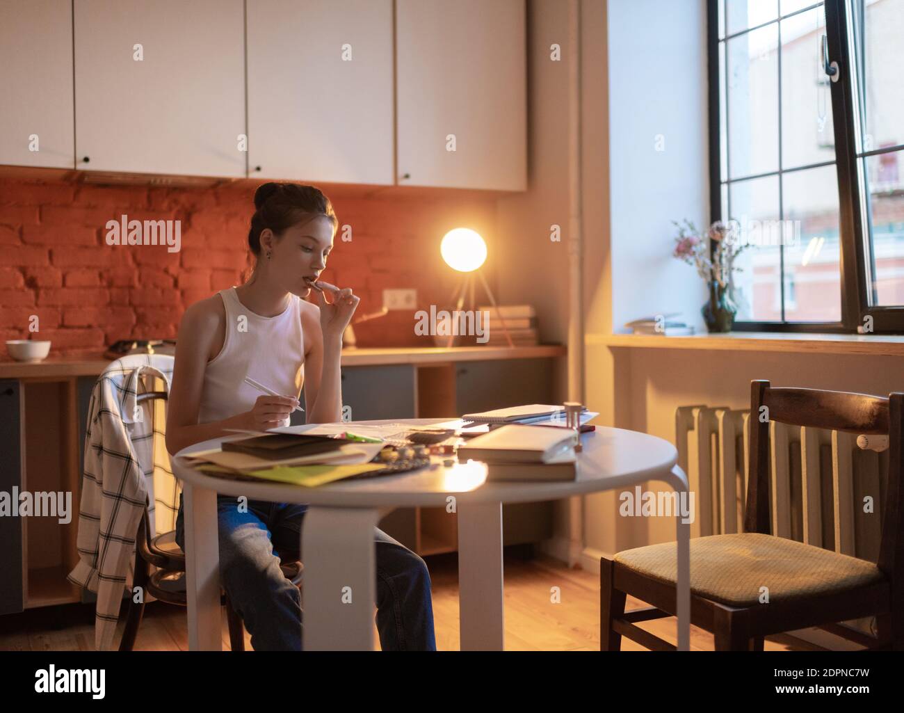 Attractive focused teenage female student taking notes for exam and ...