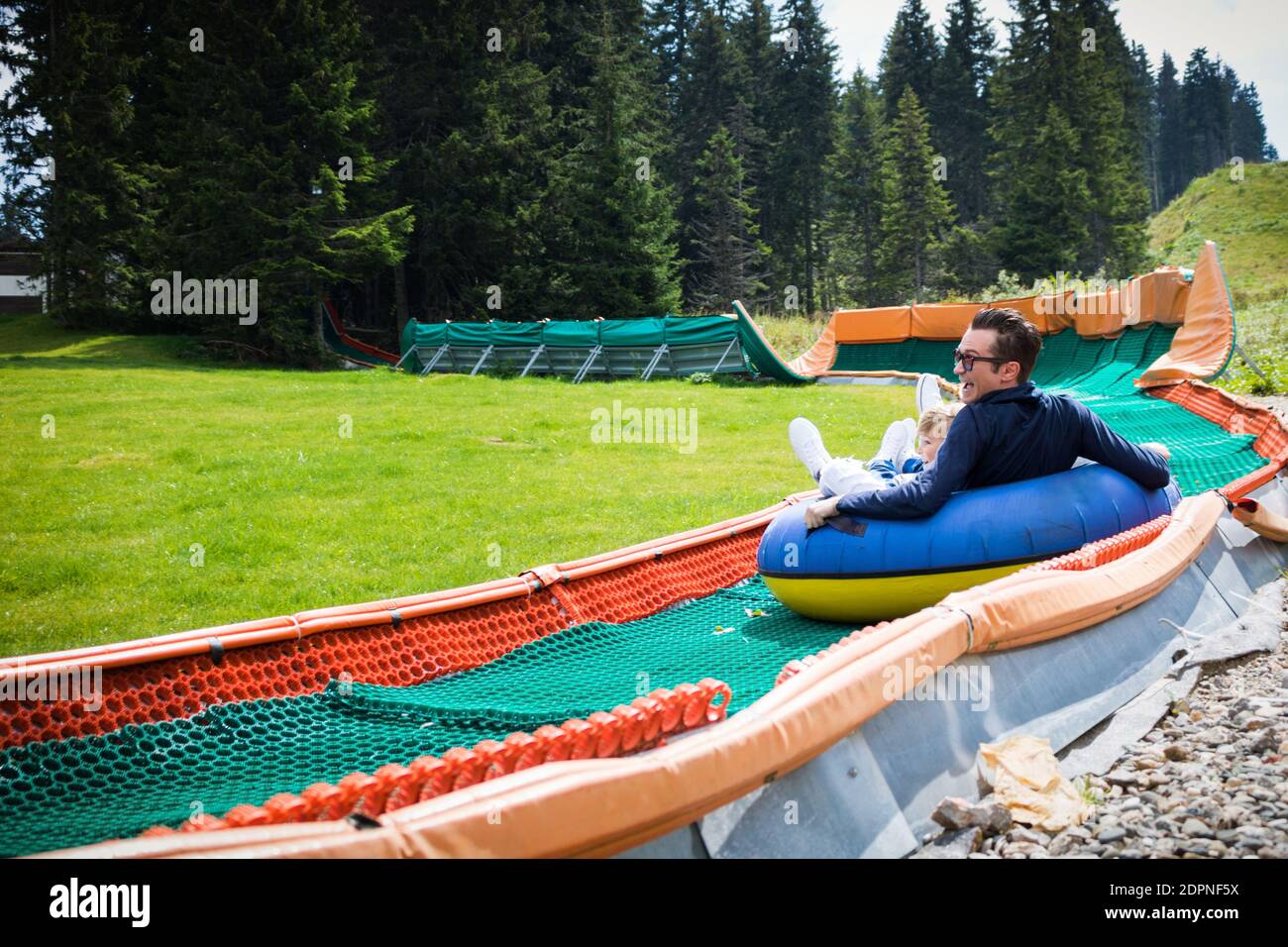 Playground slide man sitting hi-res stock photography and images - Alamy