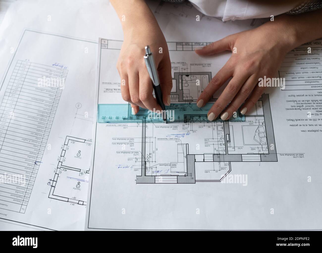 From above unrecognizable designer using ruler and pen to draw line on ...