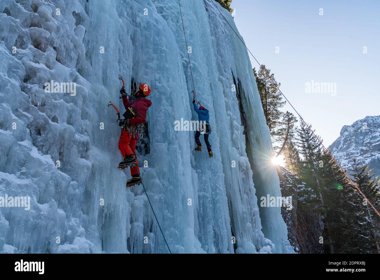 Ice climbers enjoying a day outside climbing frozen waterfalls in ...