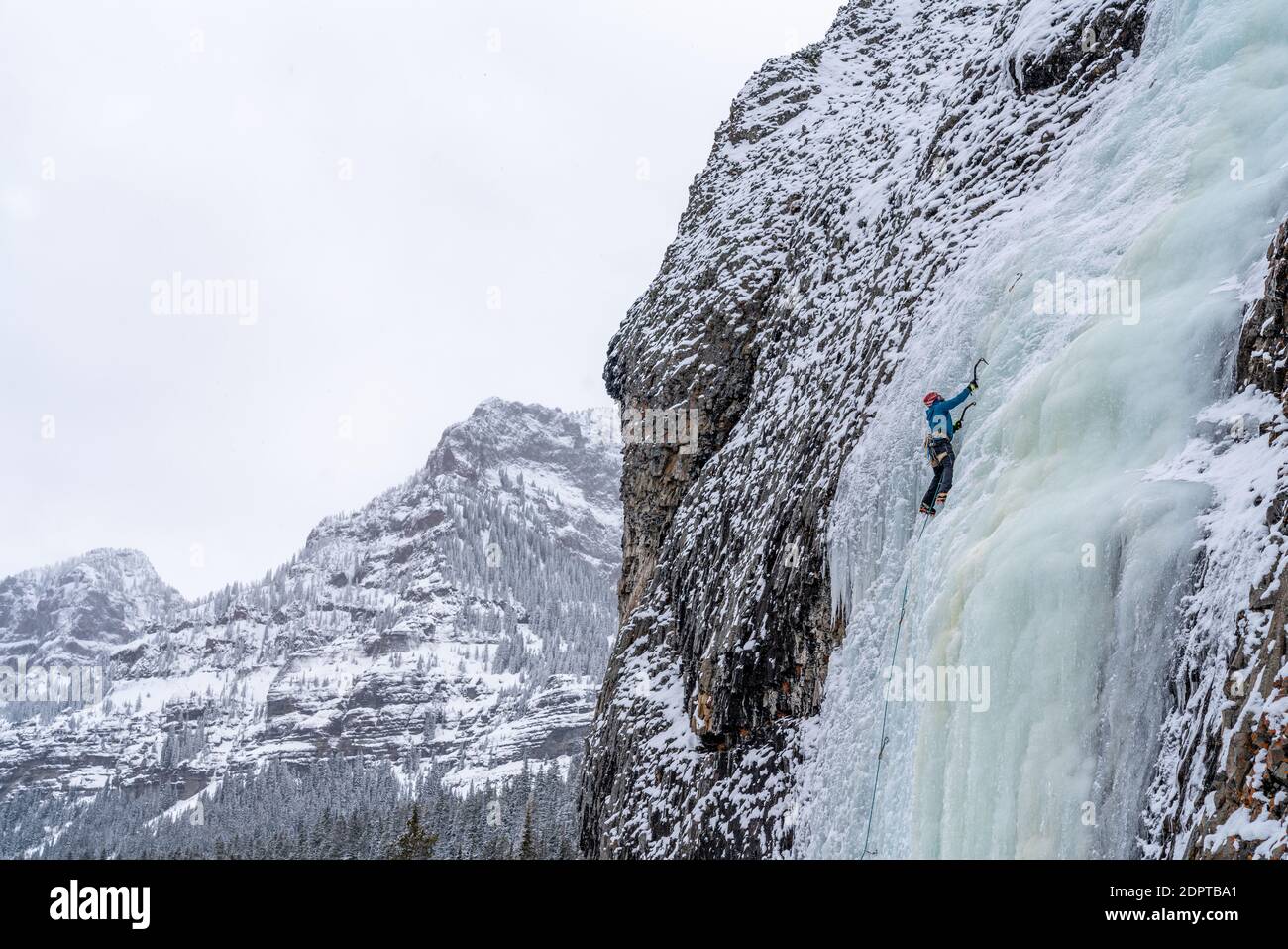 Ice climbers enjoying a day outside climbing frozen waterfalls in ...