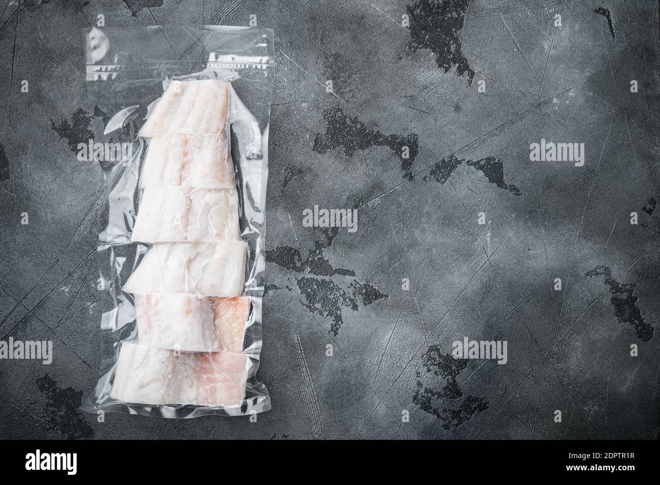 Raw haddock fish skinless plastic vacuum packaged, on gray background ...