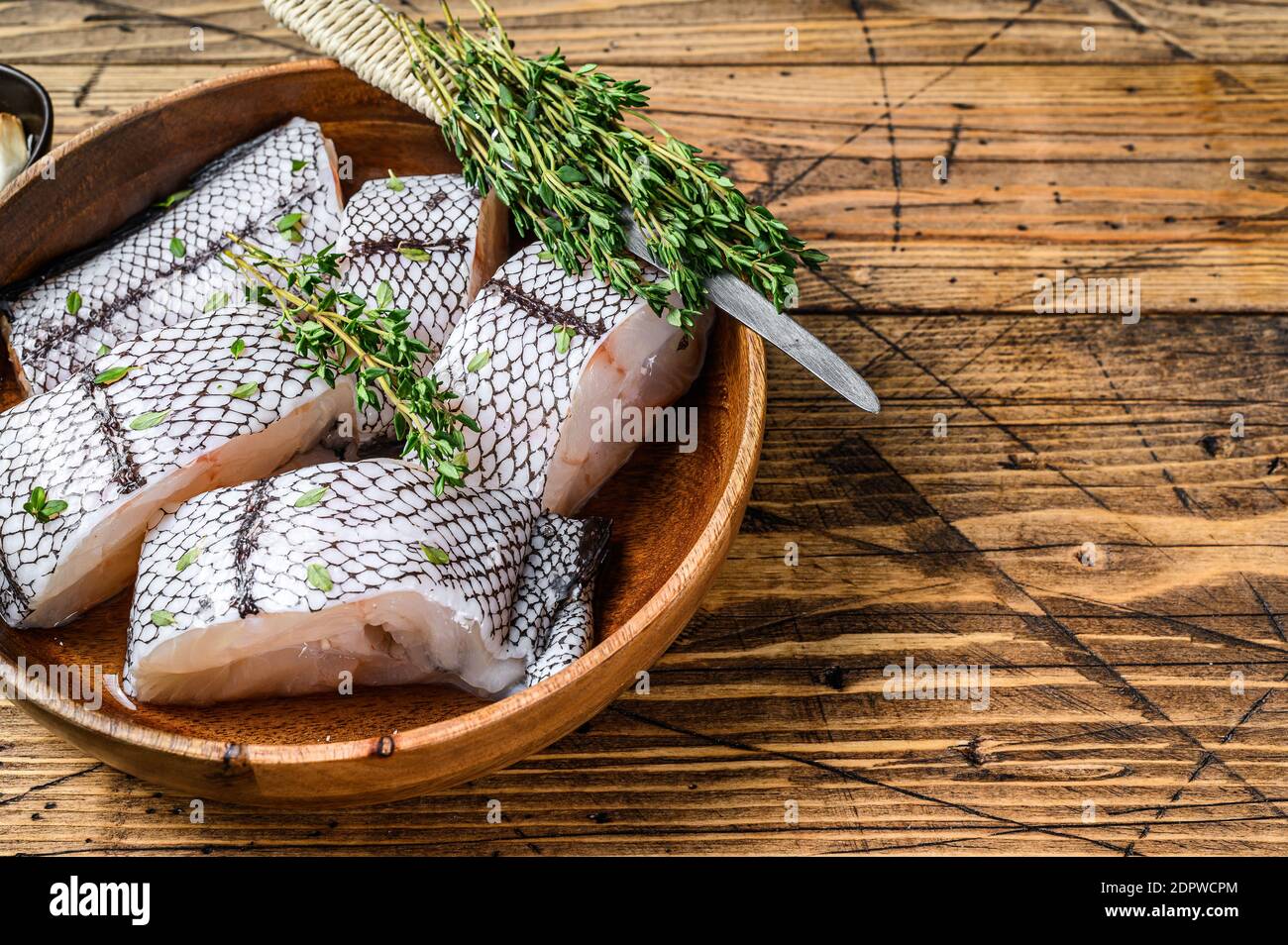 Cut Raw grenadier macrurus white fish without head in a wooden plate ...