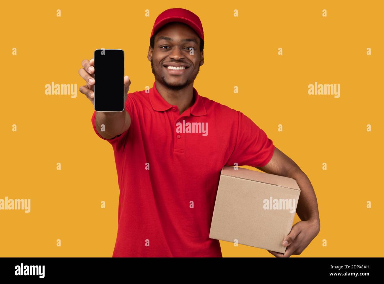 Black courier showing cellphone with blank screen, holding box Stock ...