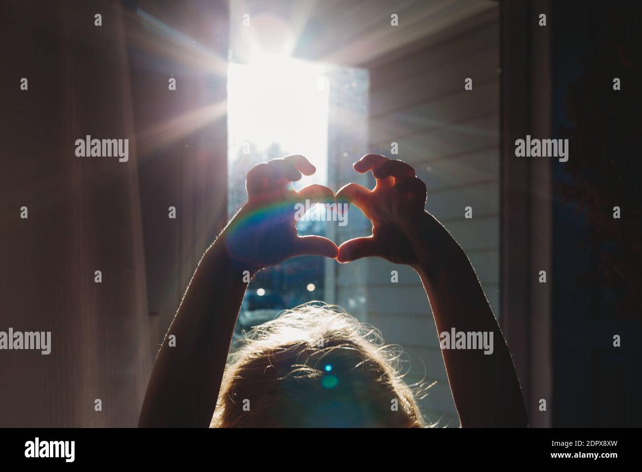 Girl With Arms Raised Making Heart Shape Over Head At Home Stock Photo ...