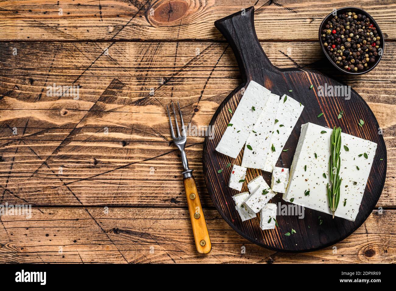 Cut cheese feta with rosemary on a wooden cutting board. wooden ...