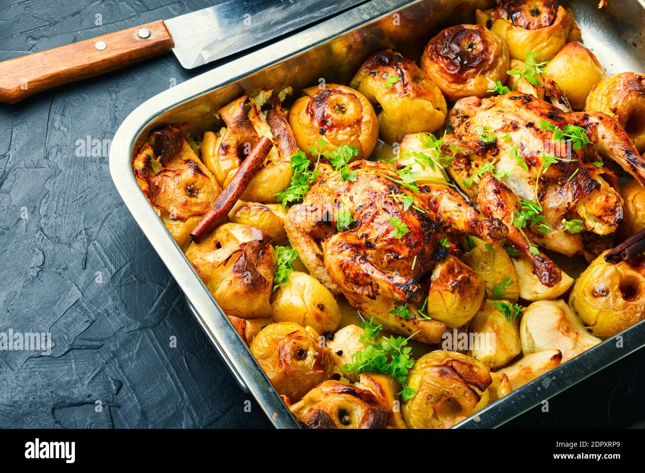 Delicious baked partridge with apples in an iron tray Stock Photo - Alamy