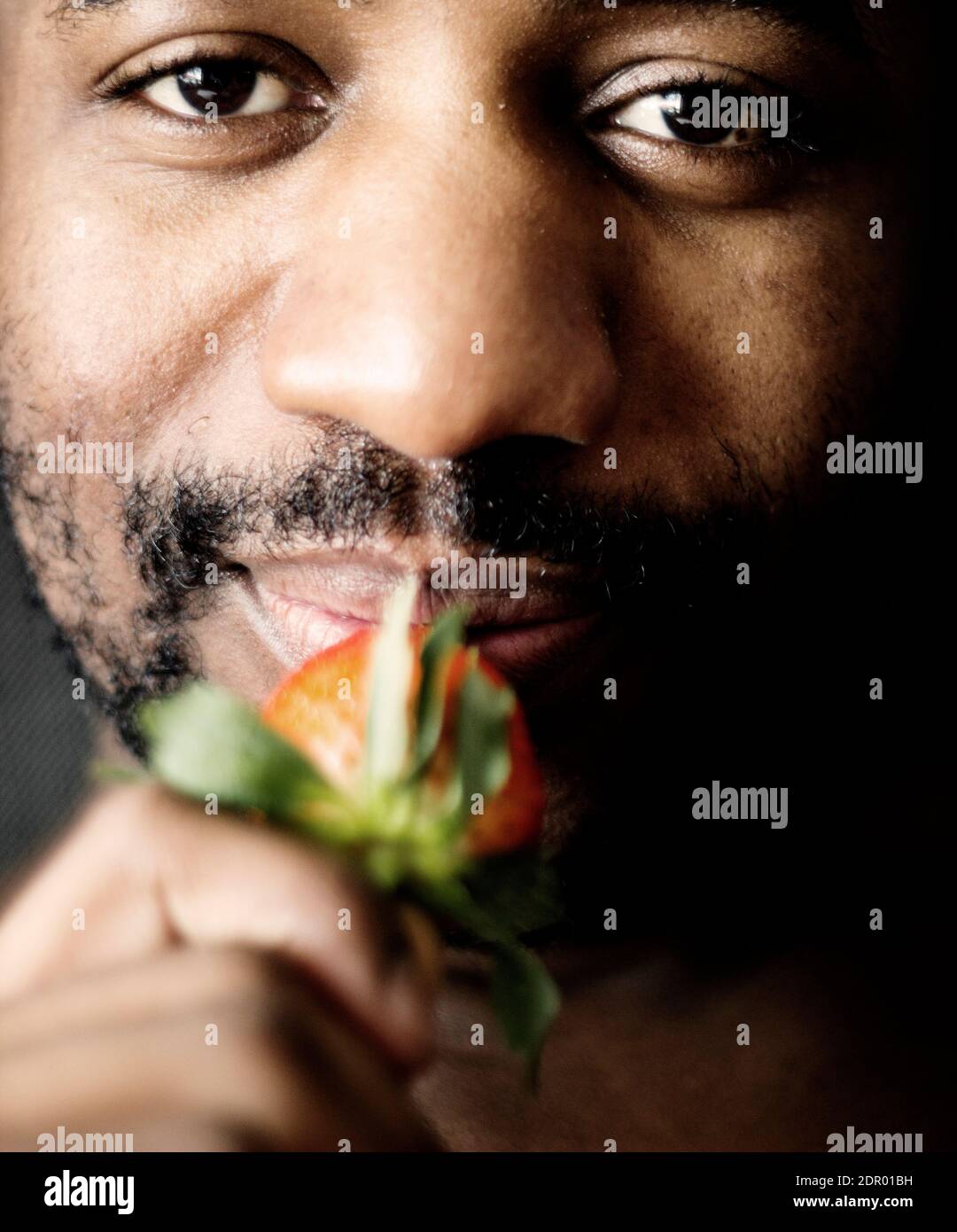 Man eating strawberry looking camera hi-res stock photography and ...