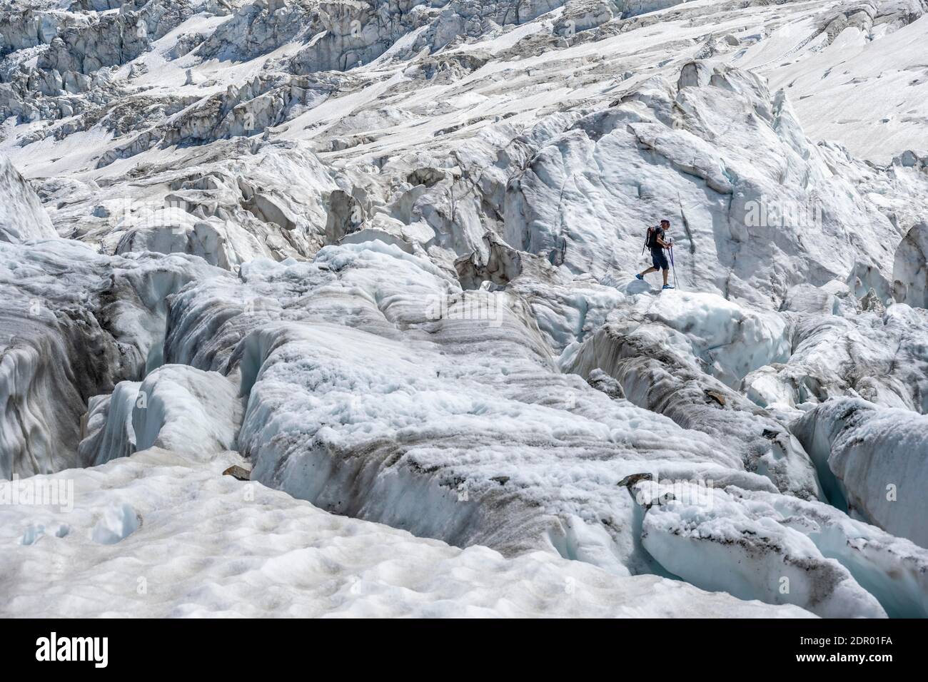 Climber walking on rutted glacier, glacier ice with crevasses, glacier ...