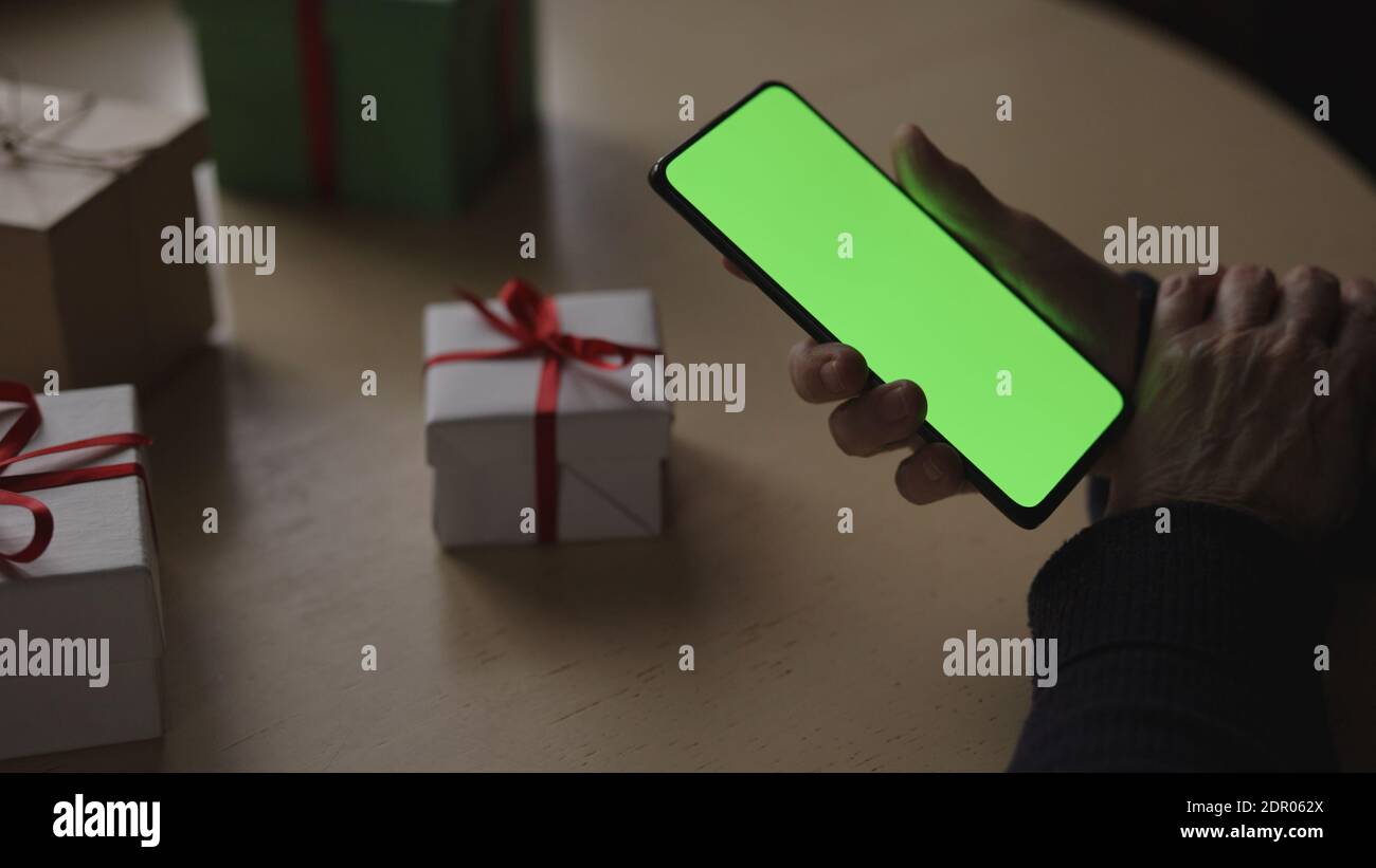 old female hands holding smartphone with green screen and celebrating ...