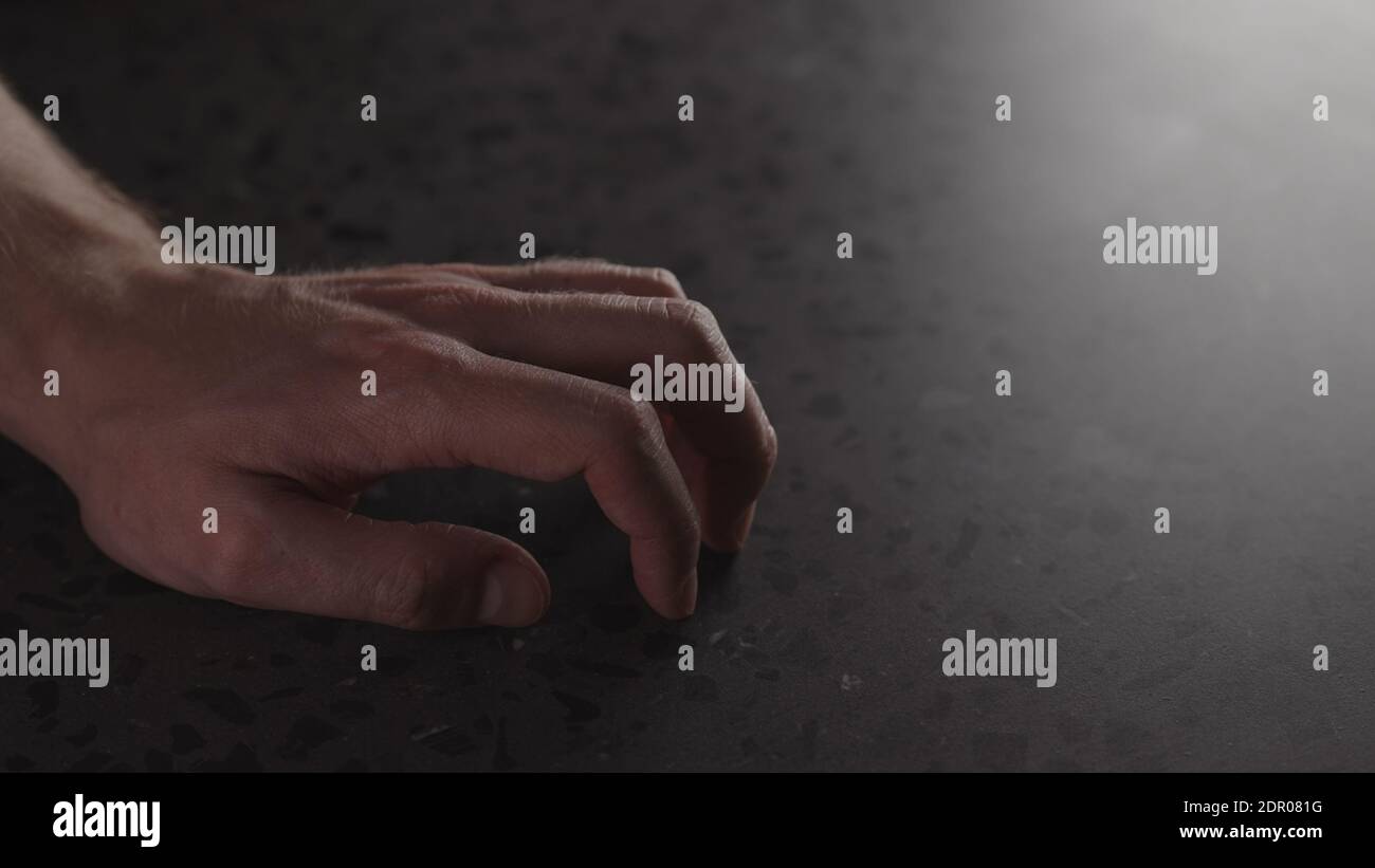young man hand finger tap on terrazzo countertop with dim light , wide ...