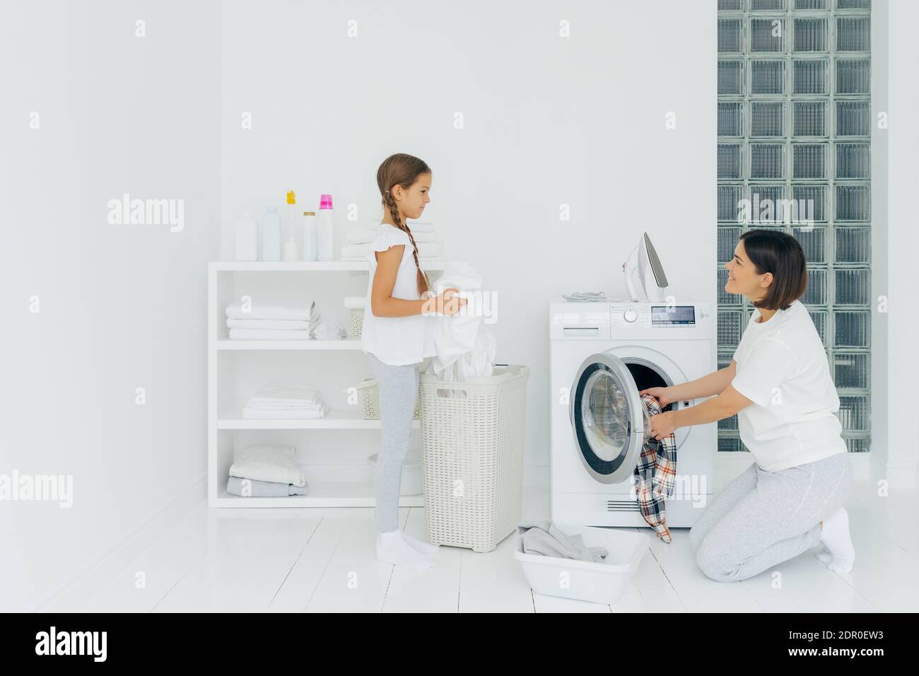 Smiling mother daughter loading washing hi-res stock photography and ...