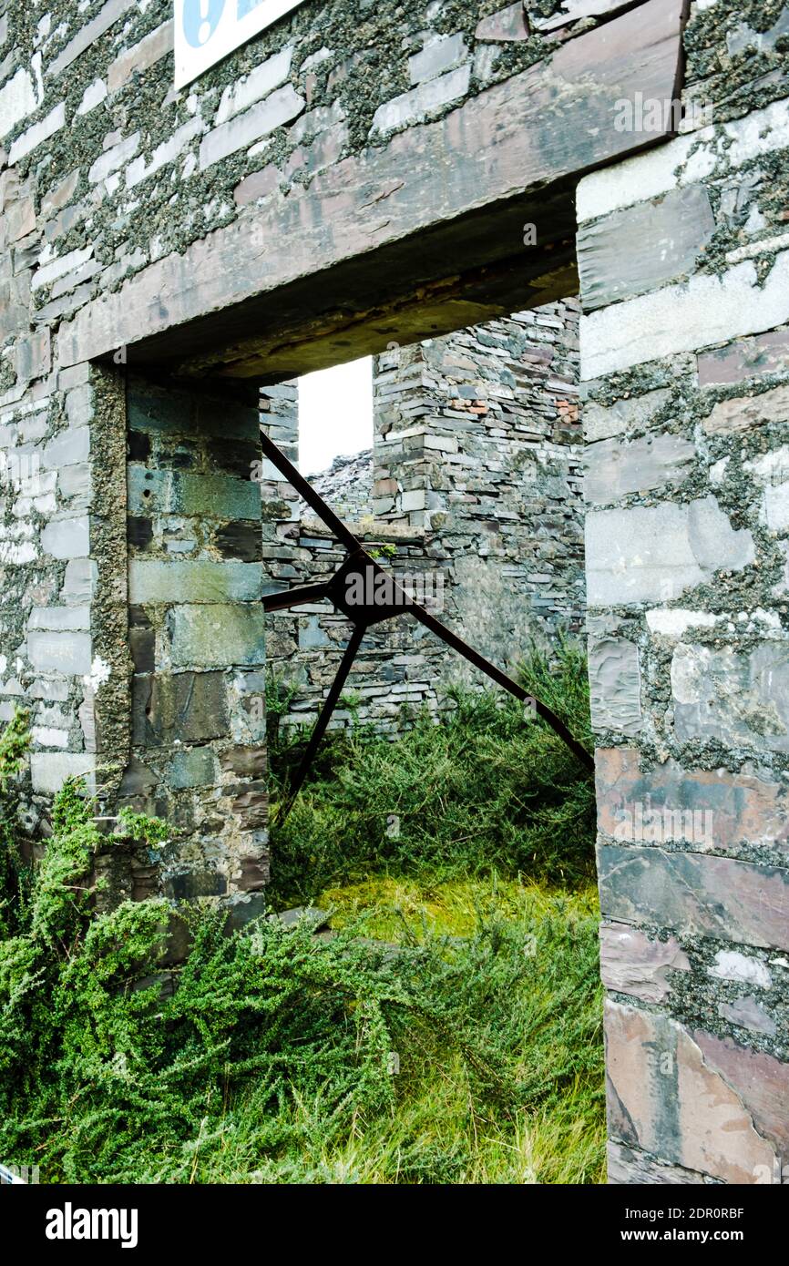 A vertical closeup shot of a stone-made abandoned building door opening ...
