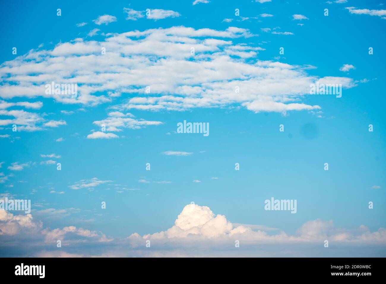 A blue-saturated summer sky with soft white clouds Stock Photo - Alamy