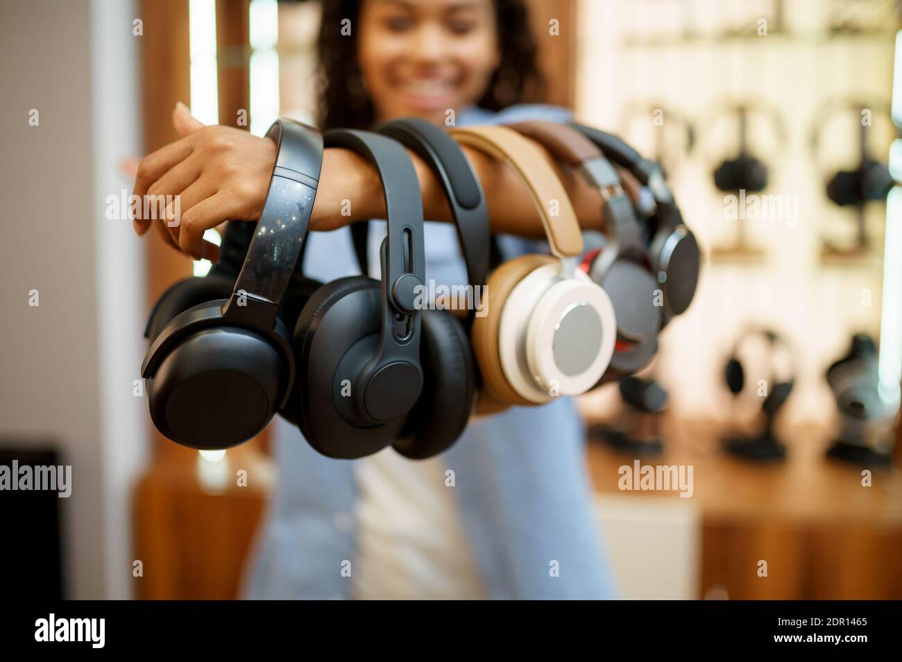 Woman shows headphones collection in audio store Stock Photo - Alamy