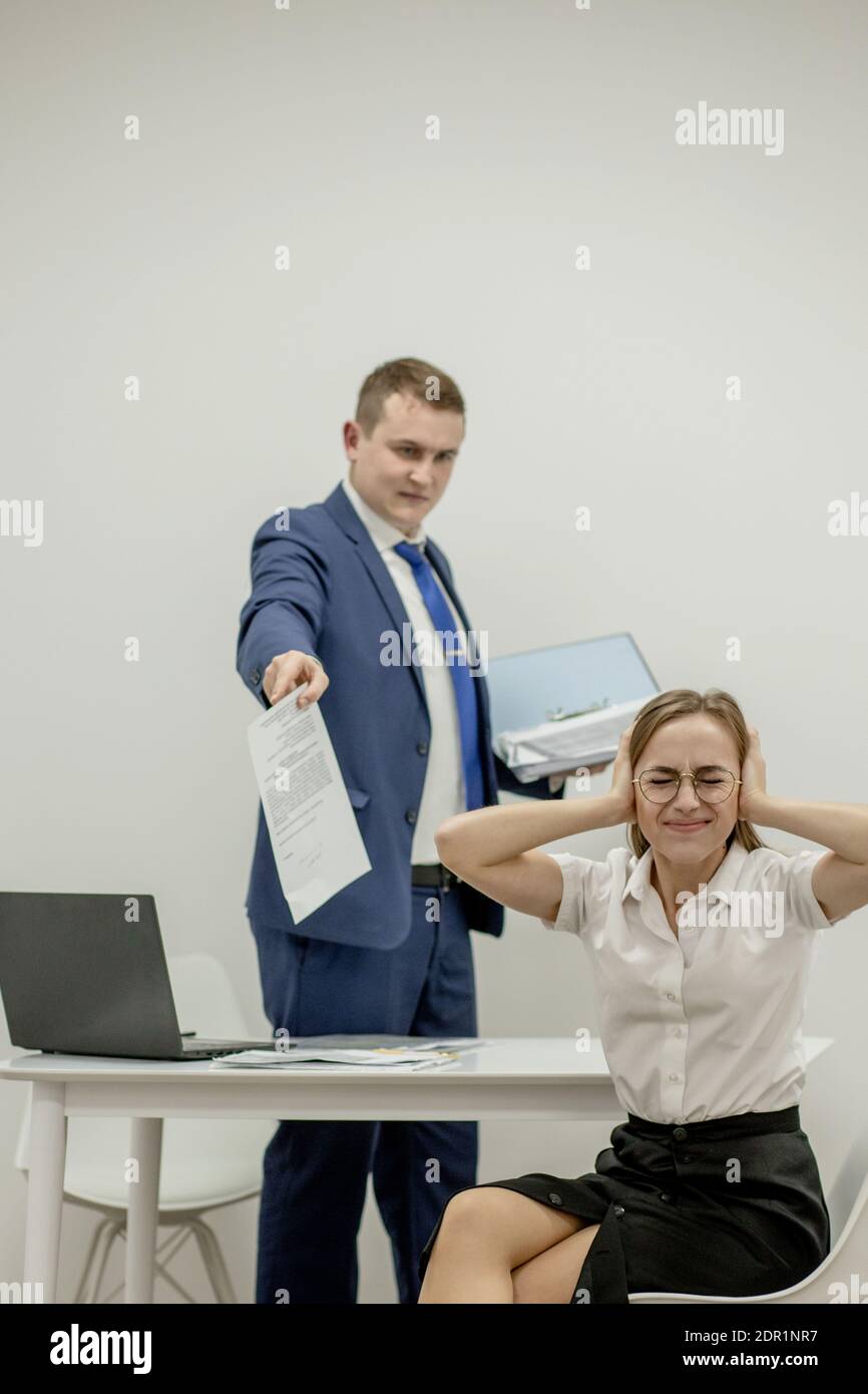 Angry boss yelling at his young employee, she is stressed and feeling ...