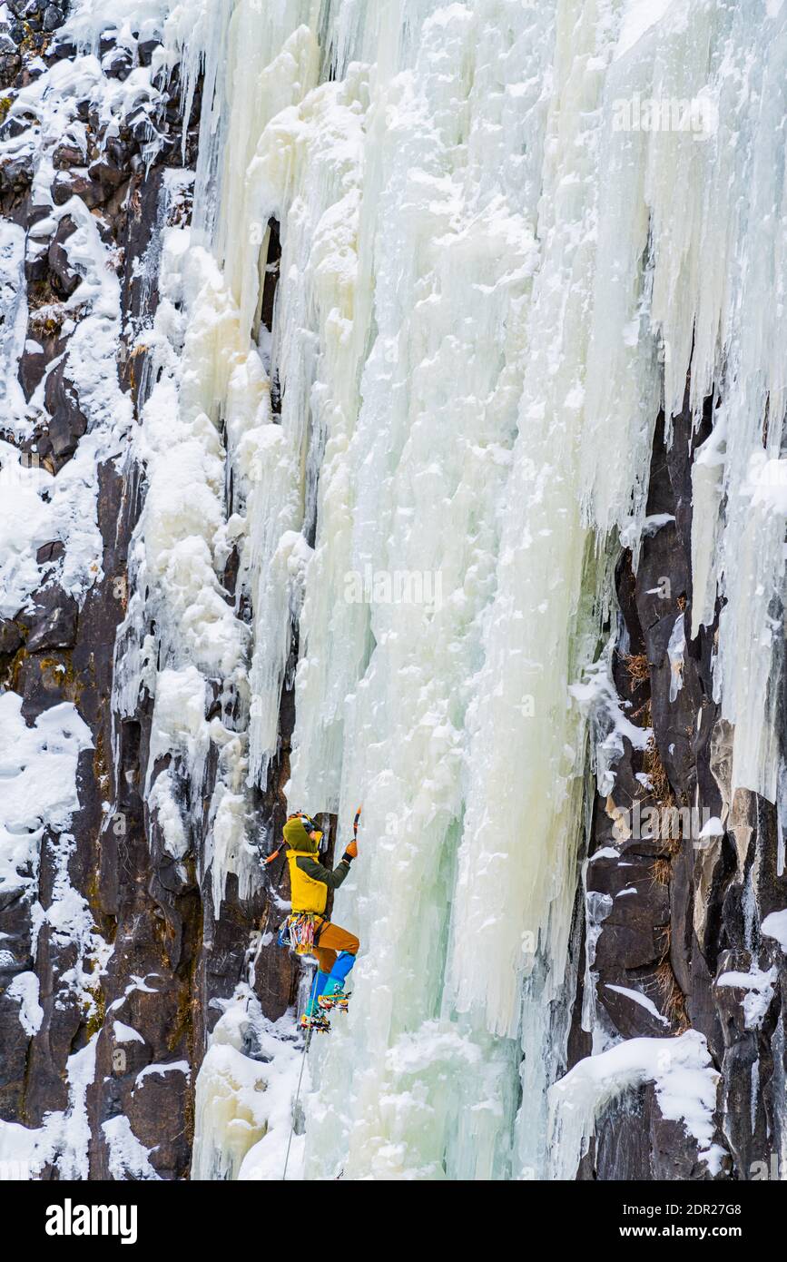 Ice climbers enjoying a day outside climbing frozen waterfalls in ...