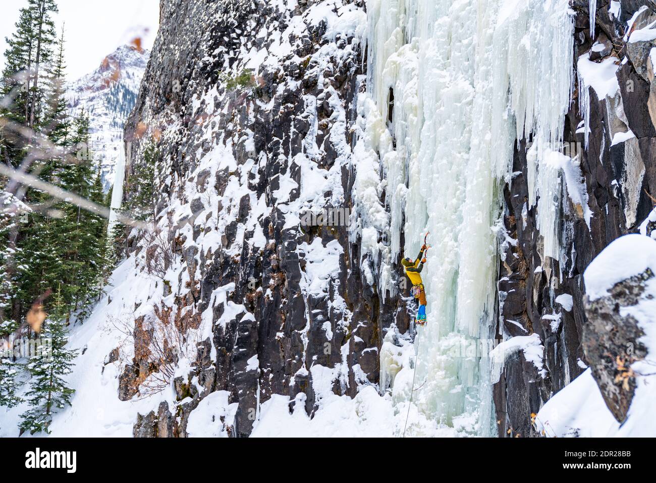 Ice climbers enjoying a day outside climbing frozen waterfalls in ...