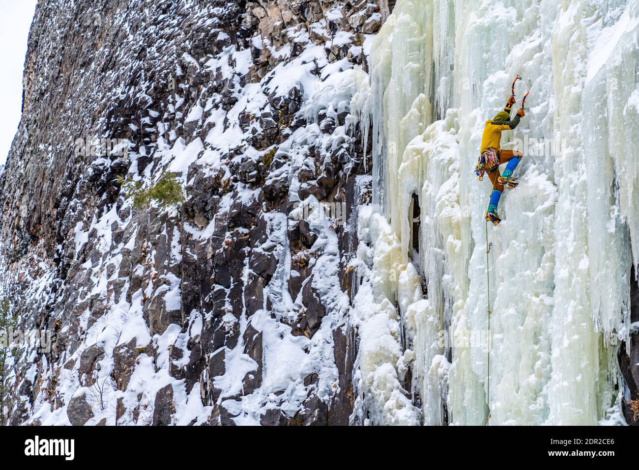 Ice climbers enjoying a day outside climbing frozen waterfalls in ...