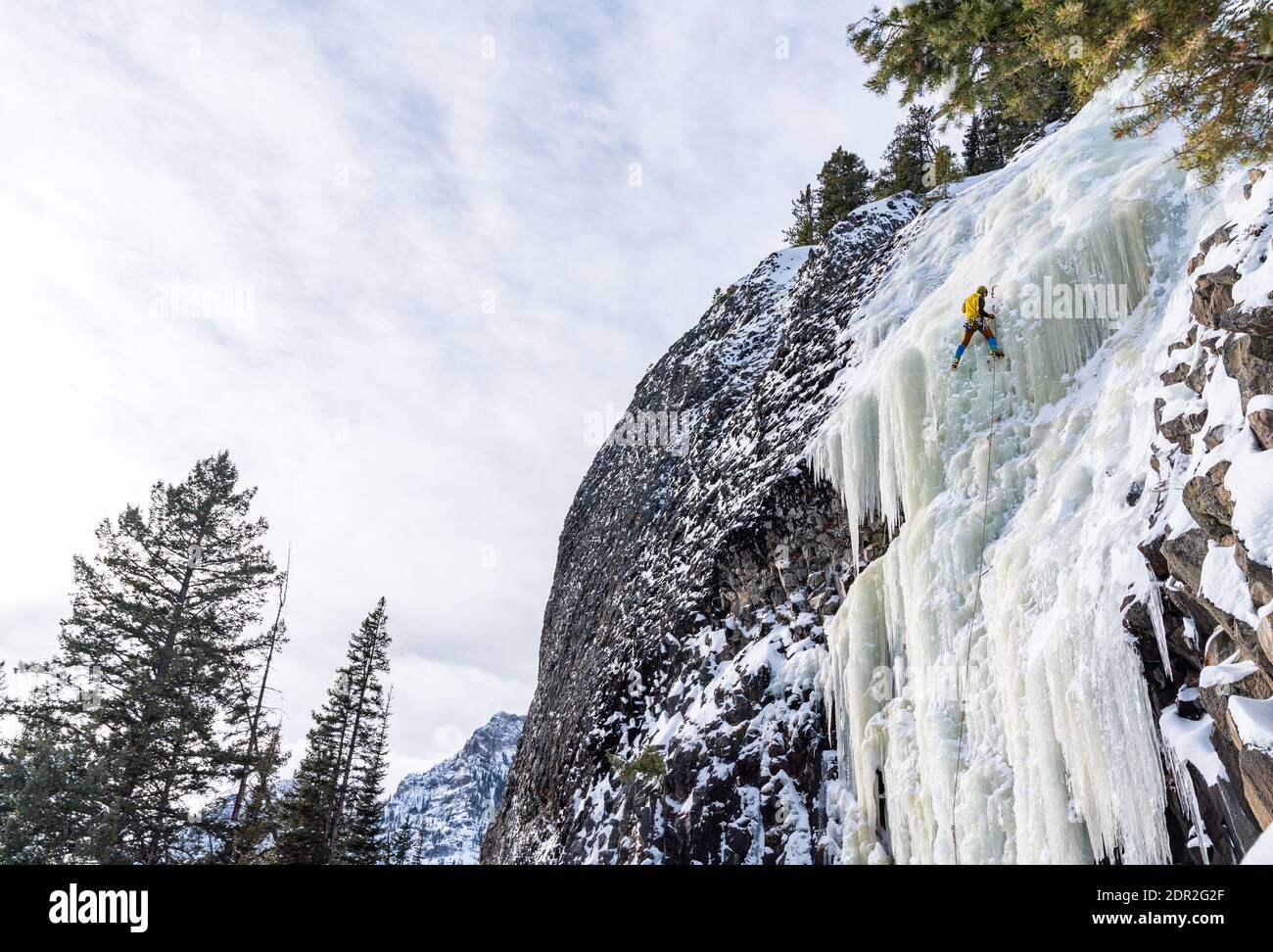 Ice climbers enjoying a day outside climbing frozen waterfalls in ...