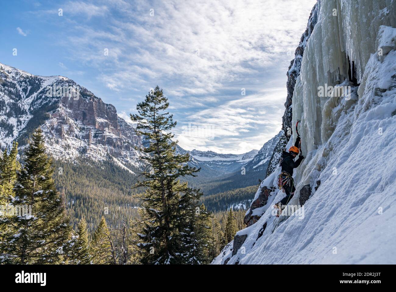 Ice climbers enjoying a day outside climbing frozen waterfalls in ...