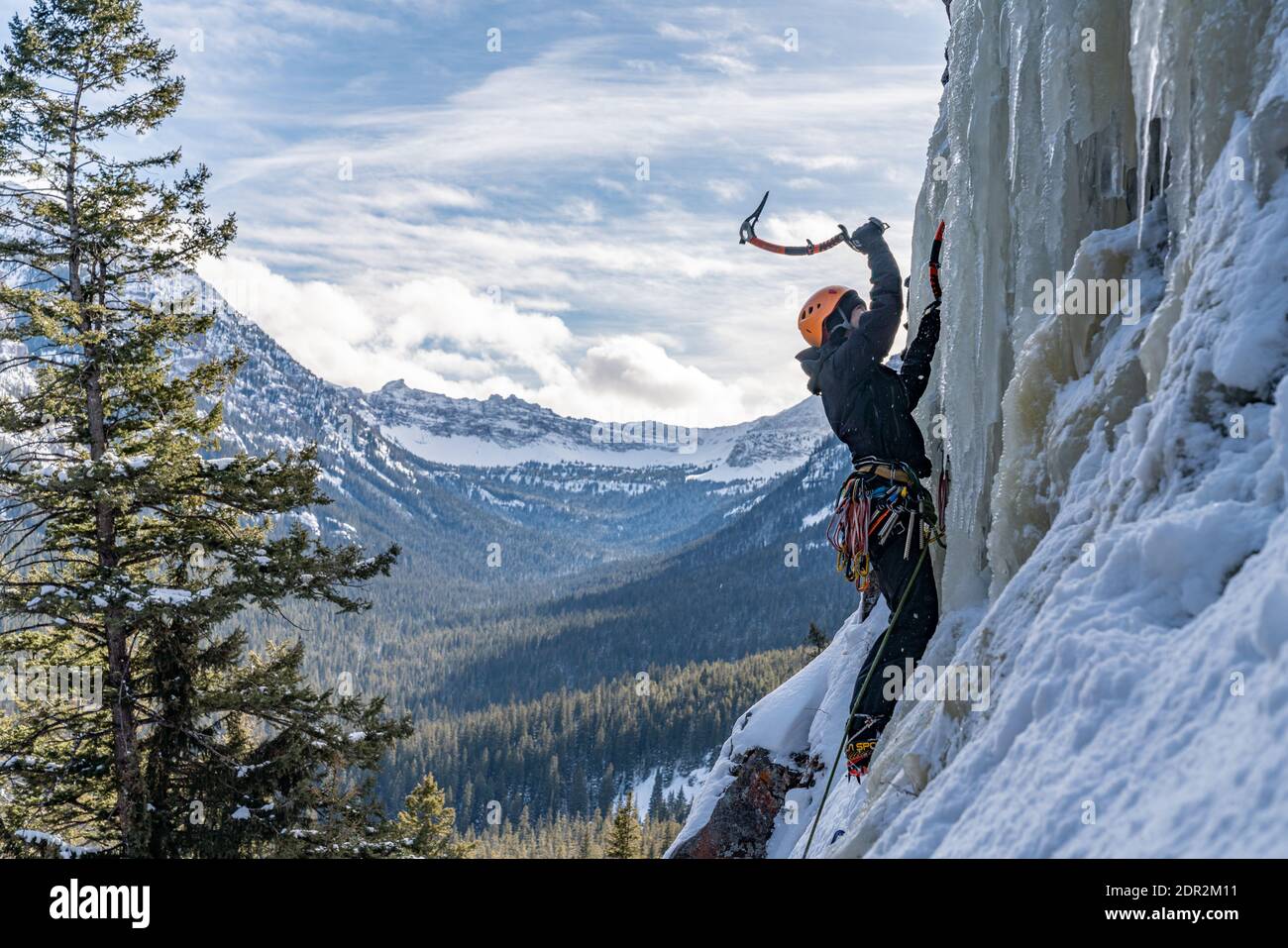 Ice climbers enjoying a day outside climbing frozen waterfalls in ...