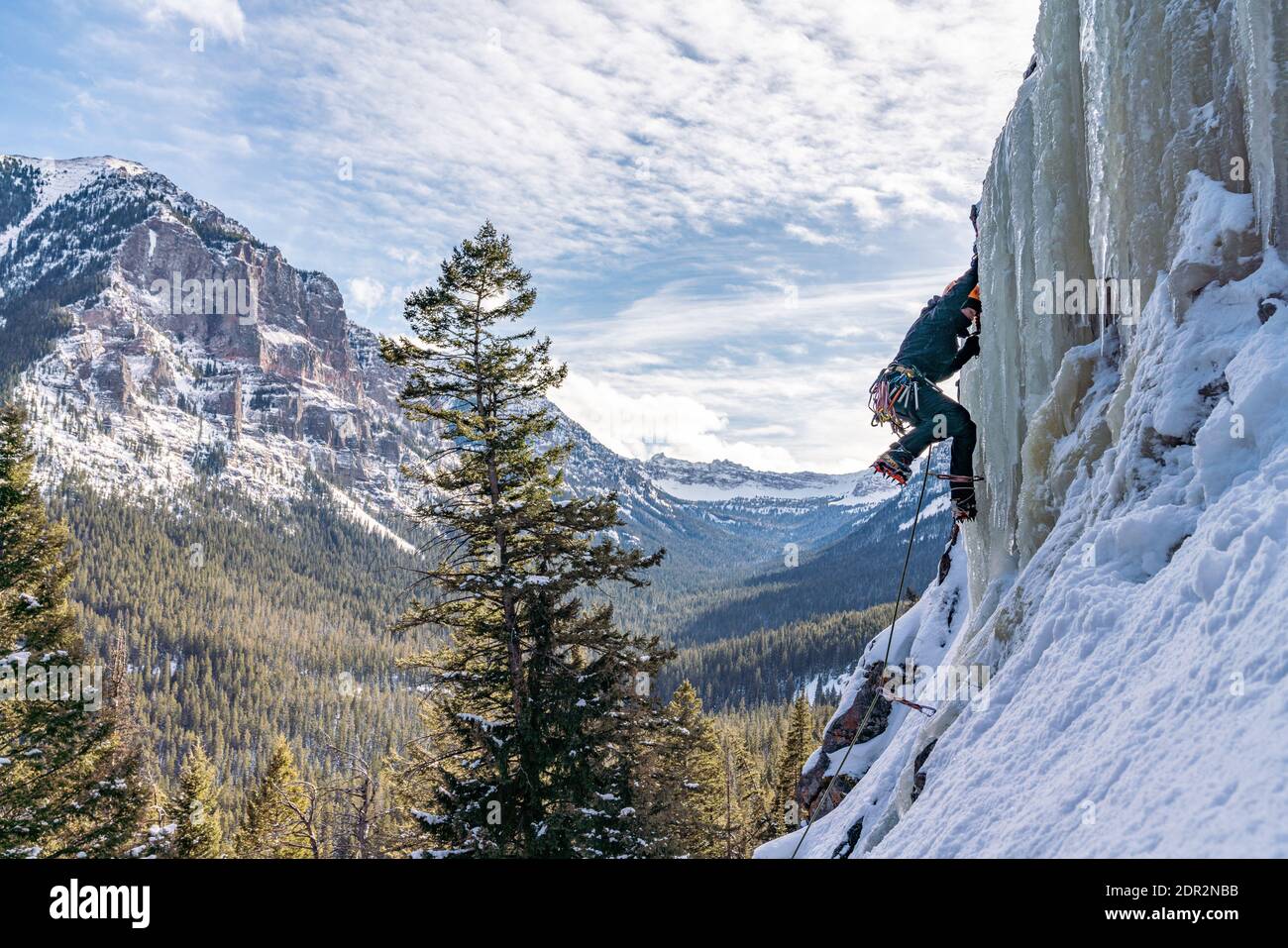 Ice climbers enjoying a day outside climbing frozen waterfalls in ...