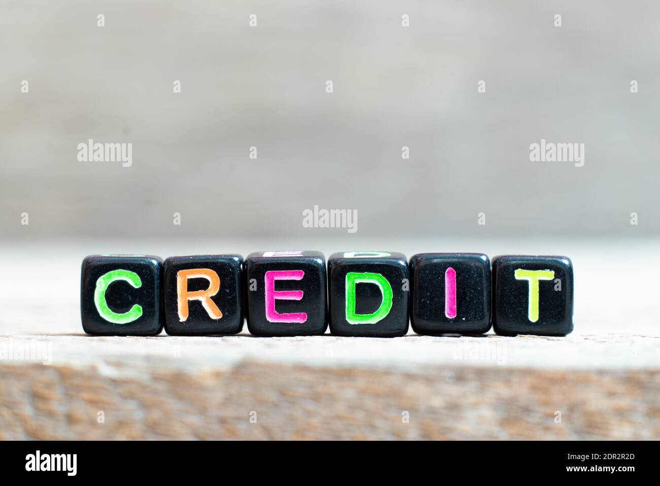 Black bead with color letter in word credit on wood background Stock ...