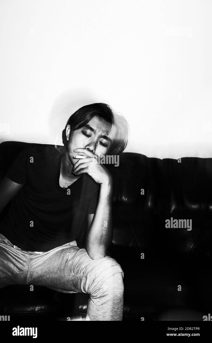 Young man smoking on sofa hi-res stock photography and images - Alamy