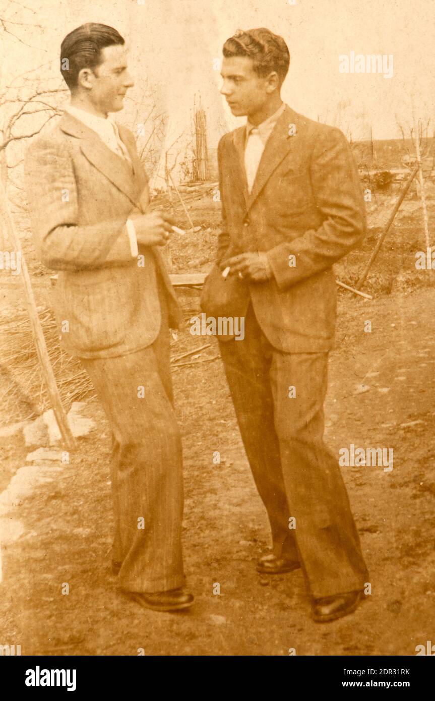 Two young, elegant italian men discussing in an unknown location in mid ...