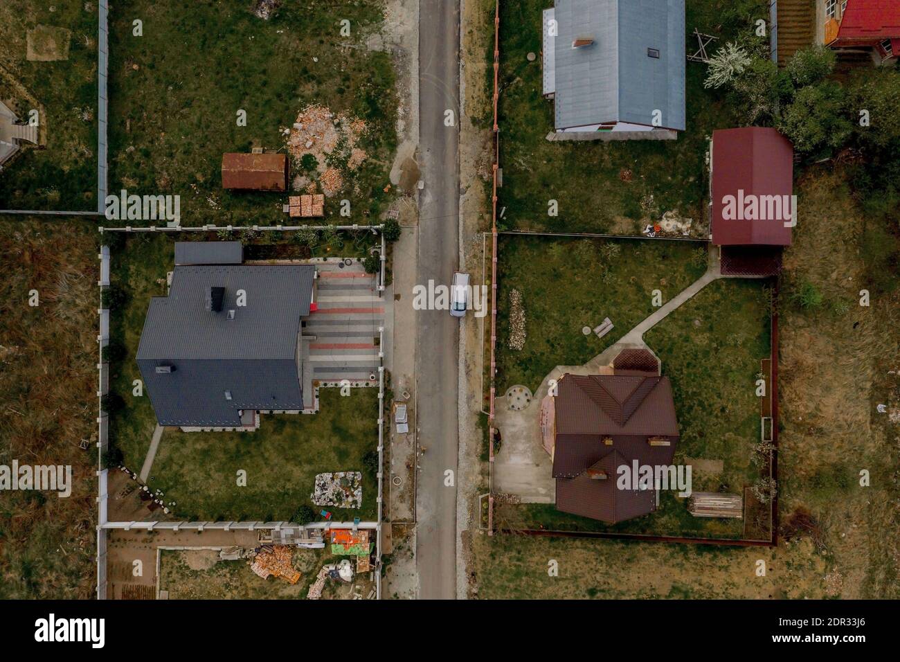 Aerial top view of a private house with paved yard with green grass ...