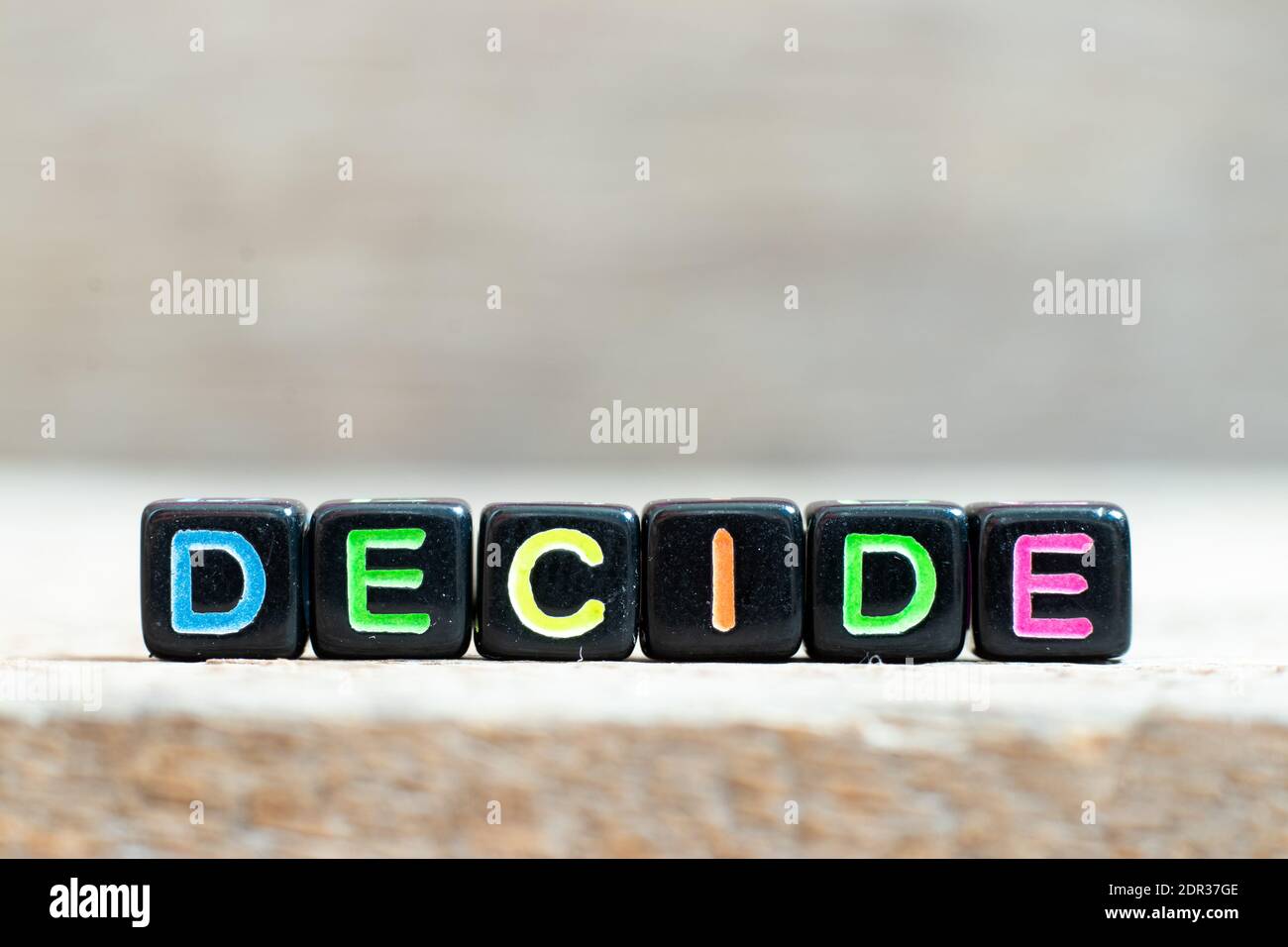 Black bead with color letter in word decide on wood background Stock ...