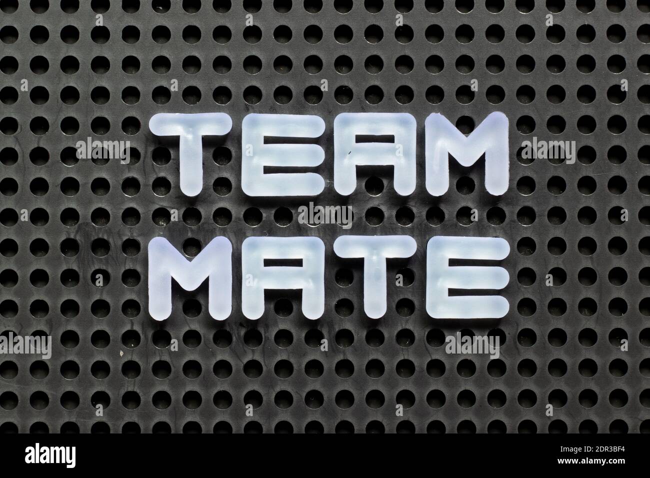 White color letter in word teammate on black pegboard background Stock ...