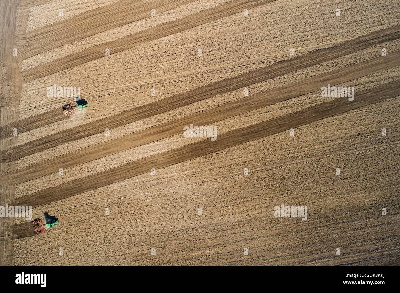 Aerial view of tractor plowing farm field in preparation for spring ...