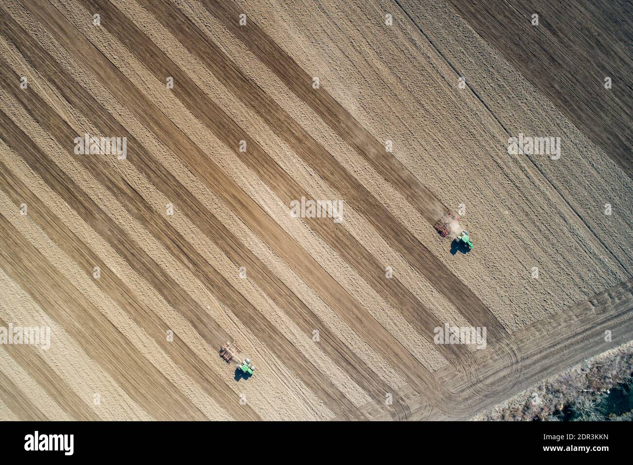 Aerial view of tractor plowing farm field in preparation for spring ...