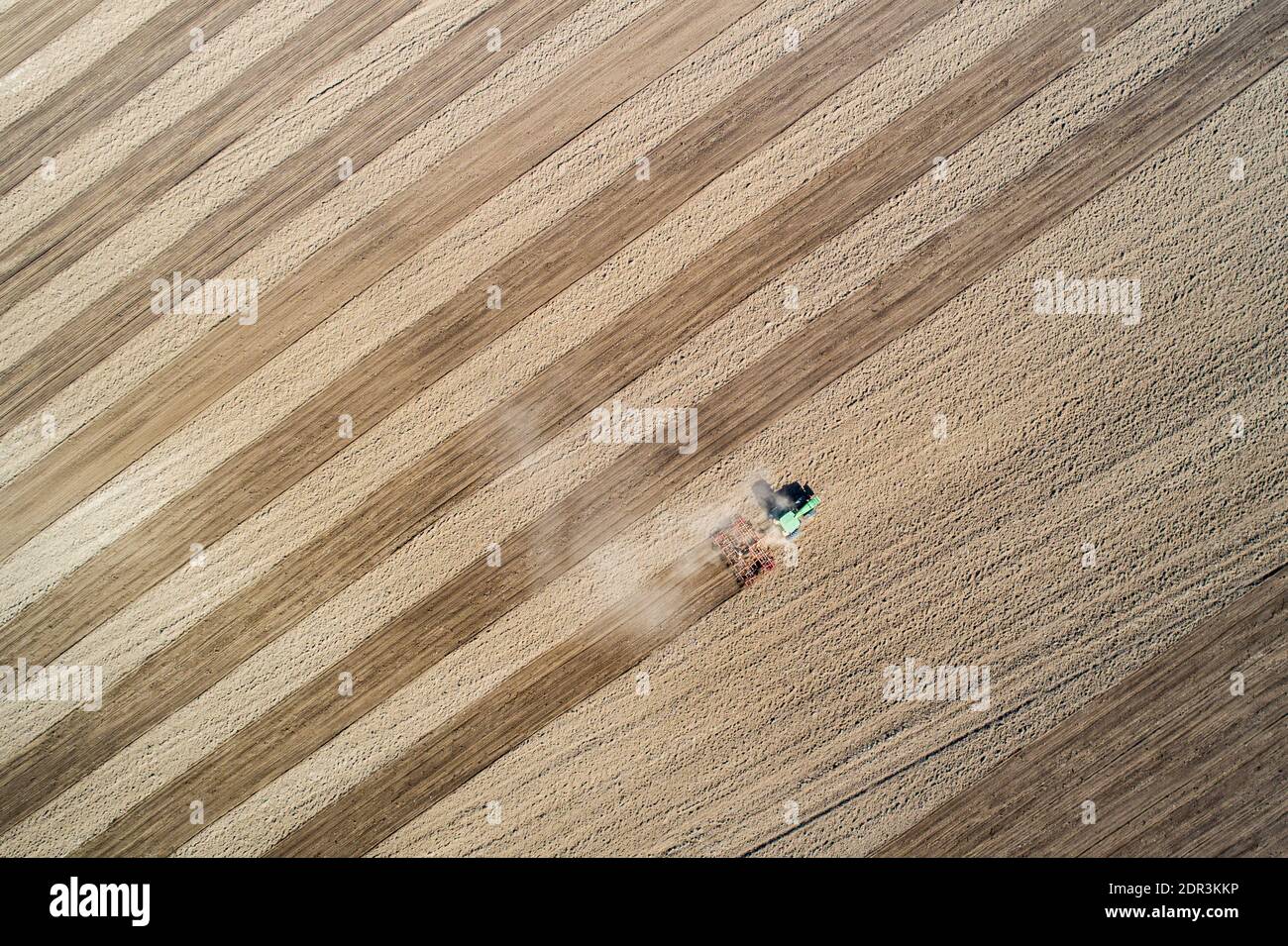 Aerial view of tractor plowing farm field in preparation for spring ...