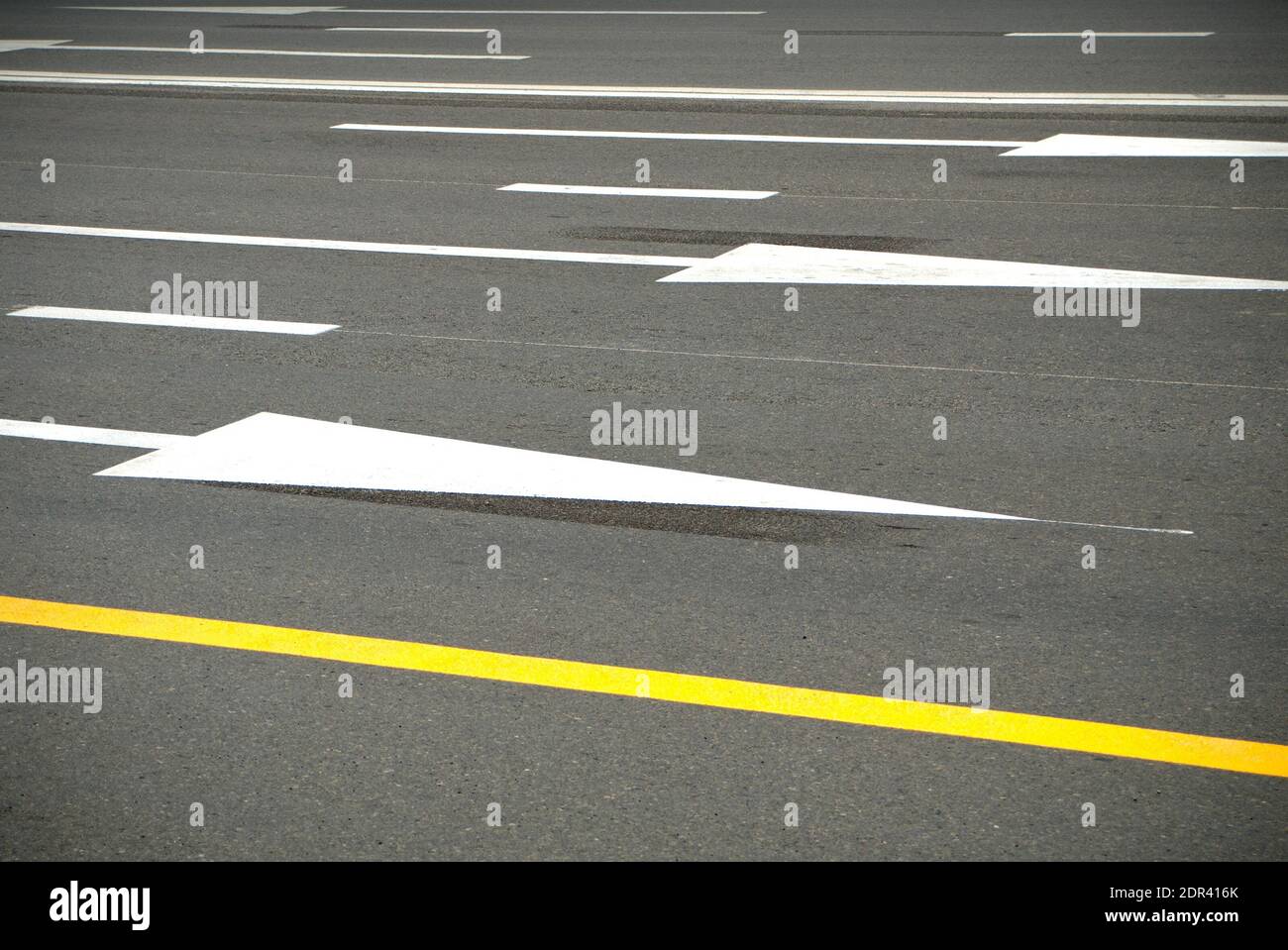 Direction arrows and lines on an asphalt road Stock Photo - Alamy