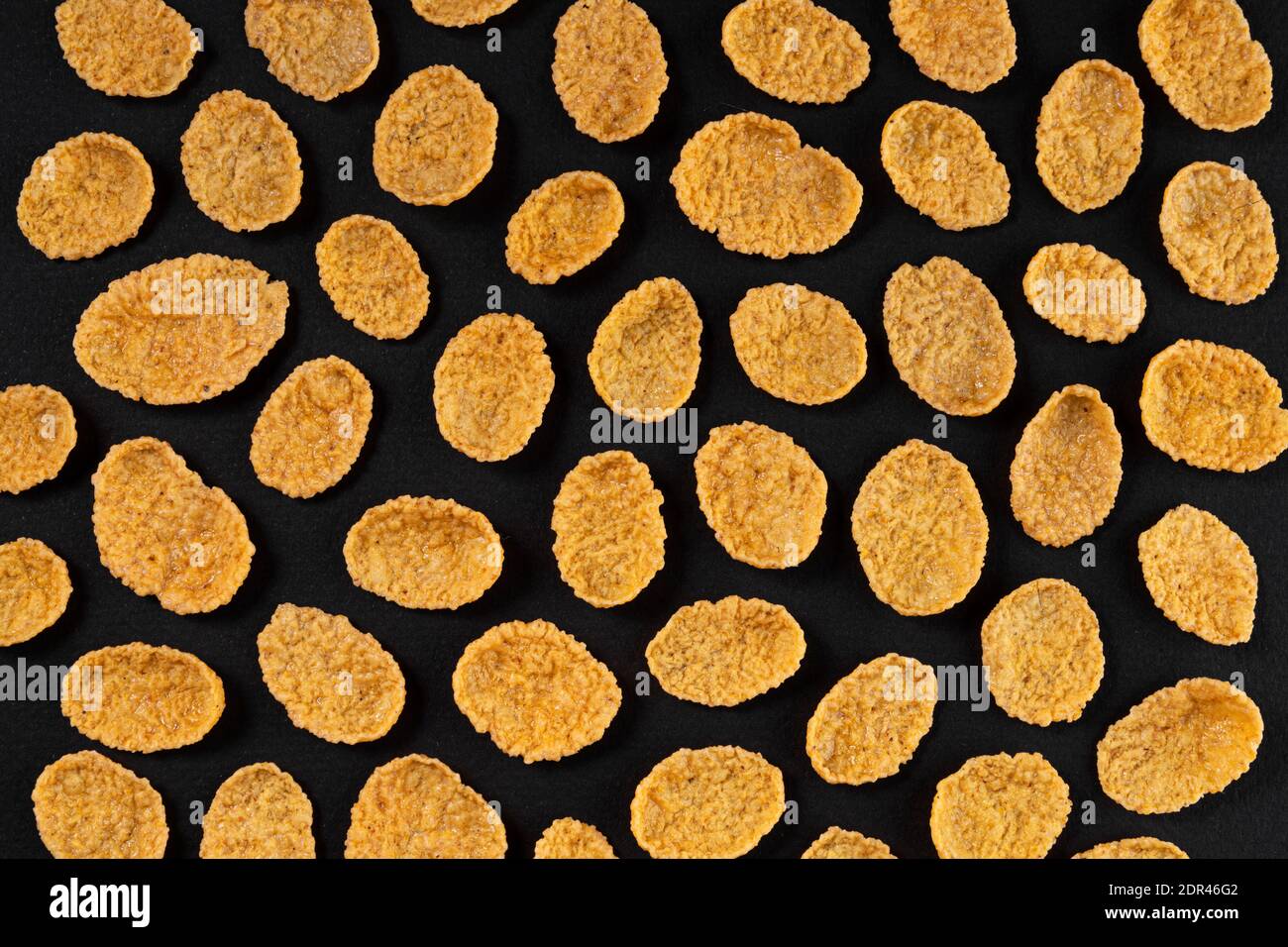 Pattern of corn flakes on black background, top view Stock Photo - Alamy