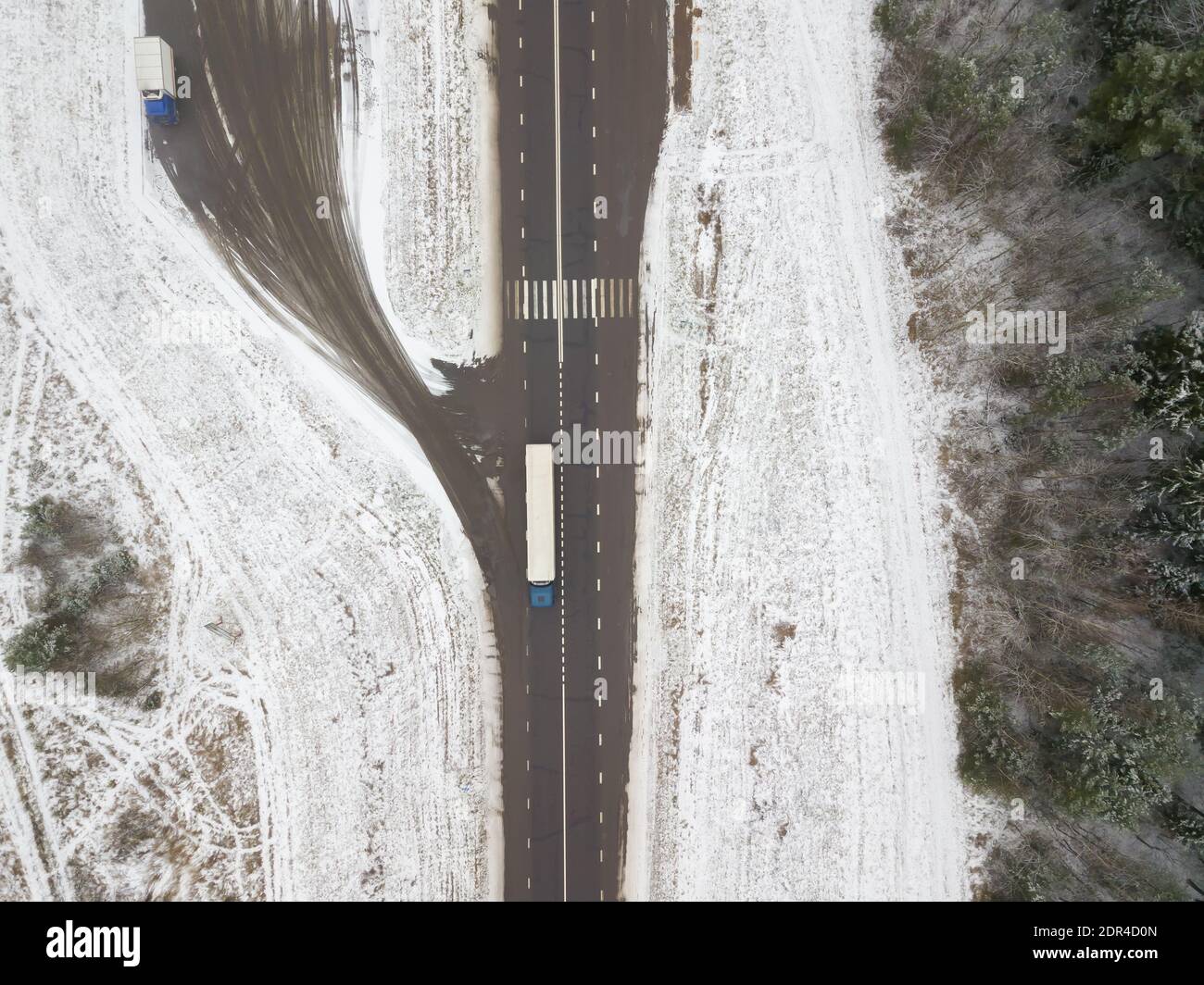 Road with pedestrian crossing the snowy forest with a large truck, the ...