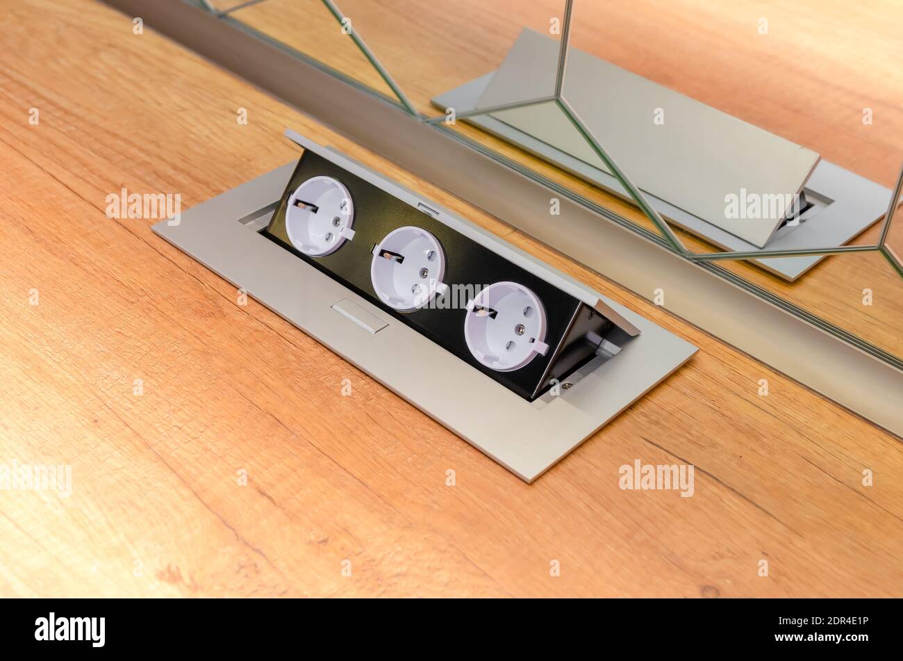 Three hidden sockets on a wooden kitchen countertop close-up, copy ...