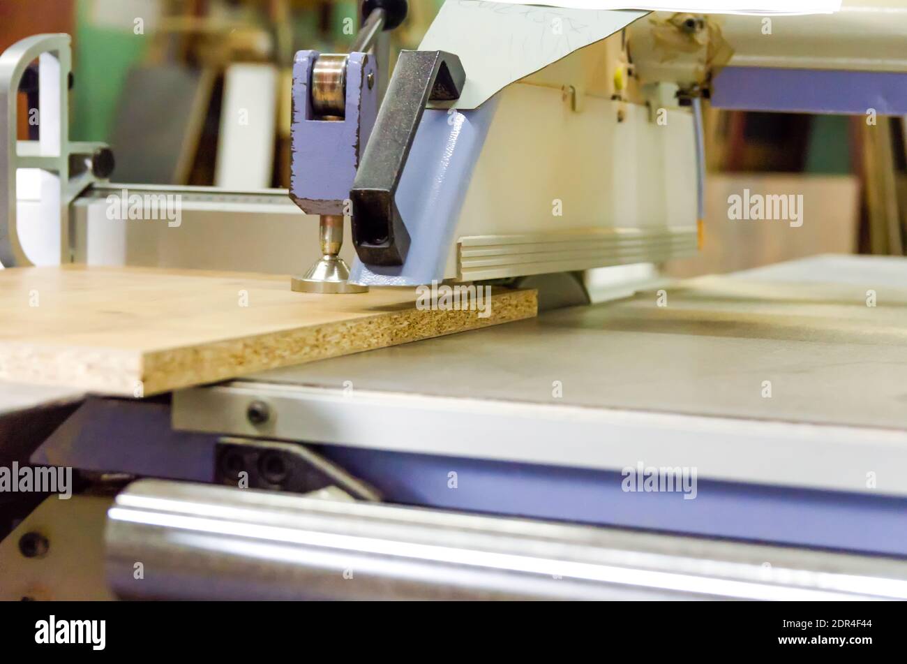 Format-cutting machine in production close-up. Woodworking machine ...