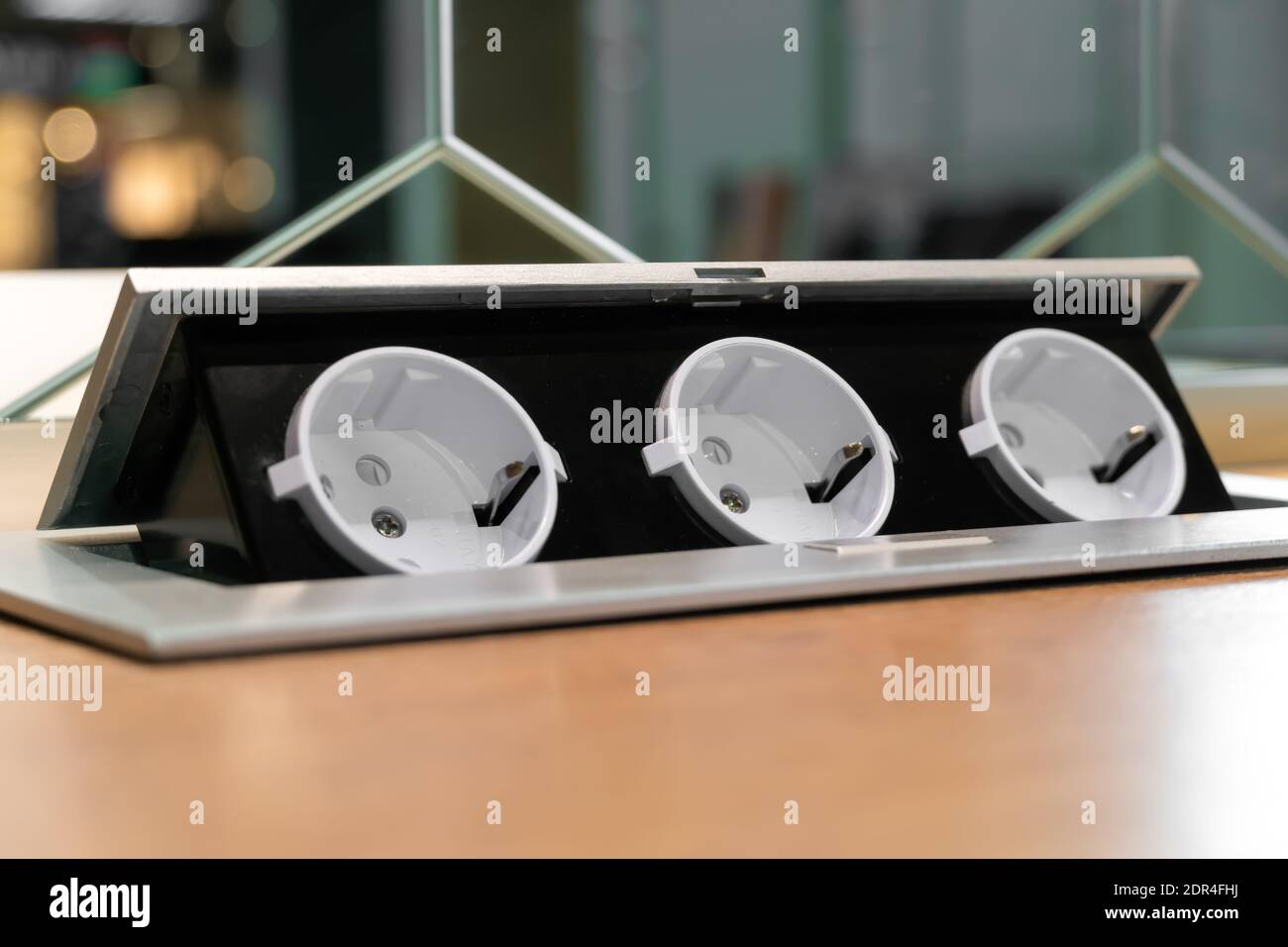 Three hidden sockets on a wooden kitchen countertop close-up, copy ...