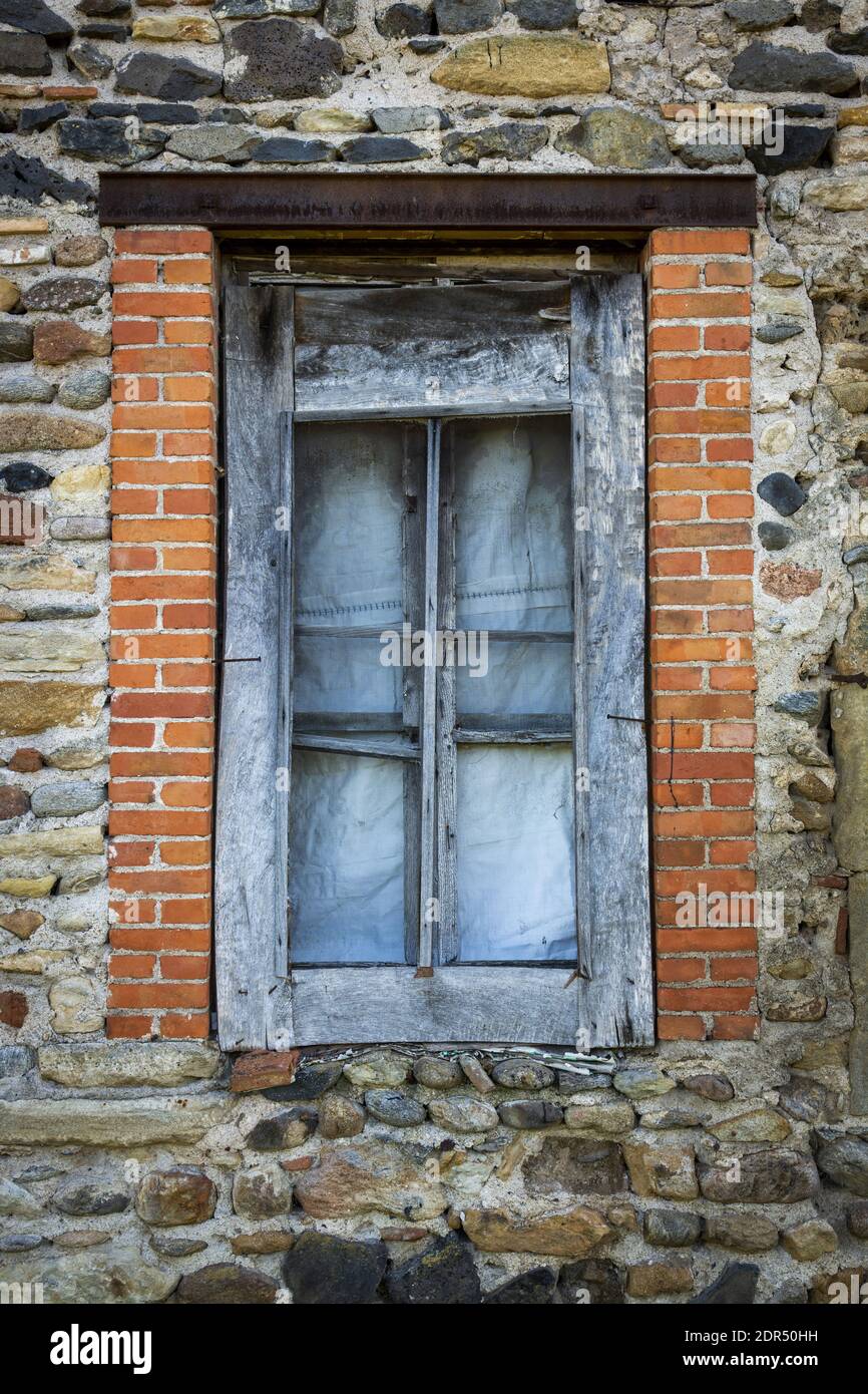 A vertical shot of a facade of a brick building with an old broken ...