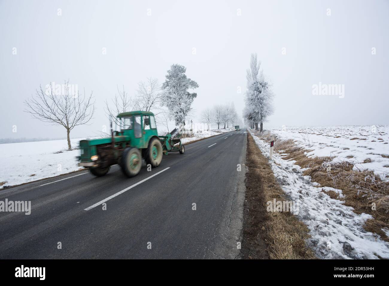 Fast moving tractor with snowy road Stock Photo - Alamy