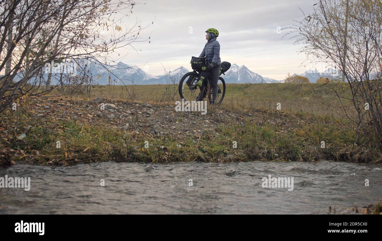 The woman travel on mixed terrain cycle touring with bikepacking. The ...