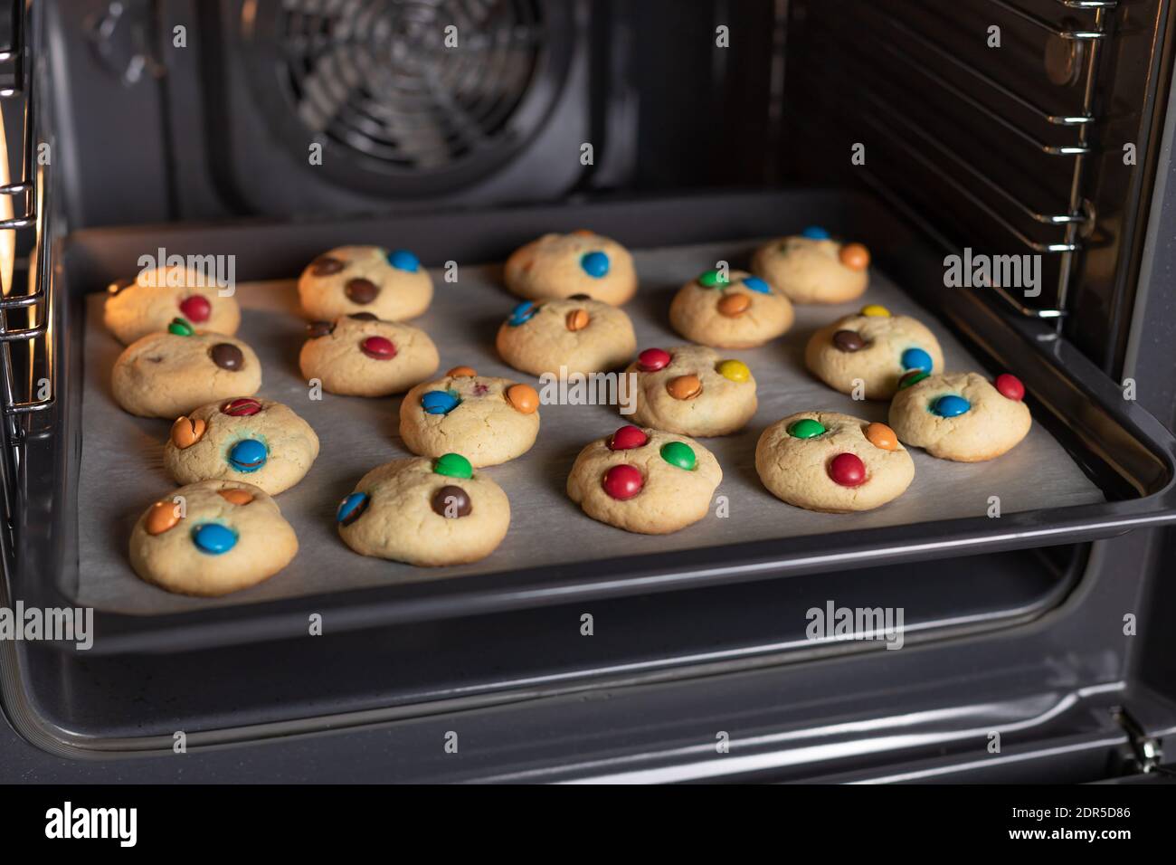 freshly baked cookies with color sweets on tray in oven Stock Photo - Alamy